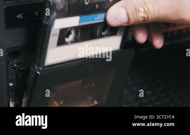 Close up of hand operating vintage boombox, ejecting and re-inserting ...