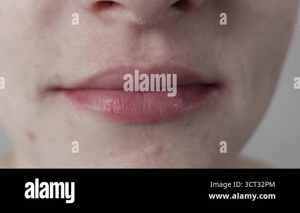 Macro close-up of a womans mouth with glossy lipstick smiling gently ...