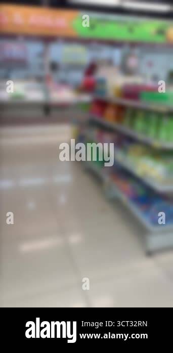 Blurred shot of supermarket interior showing a shelf display filled ...