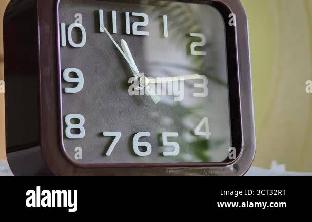 Extreme close-up on the face of a retro analog clock. A thin white ...