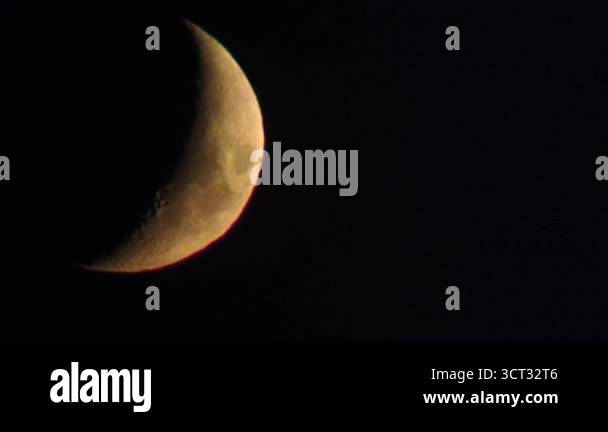 Extreme close-up view of golden crescent moon exiting frame, revealing ...