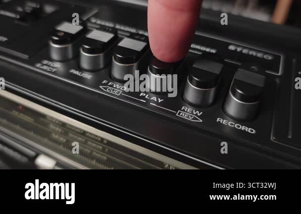 Top-down angled shot of a finger operating retro cassette recorder ...