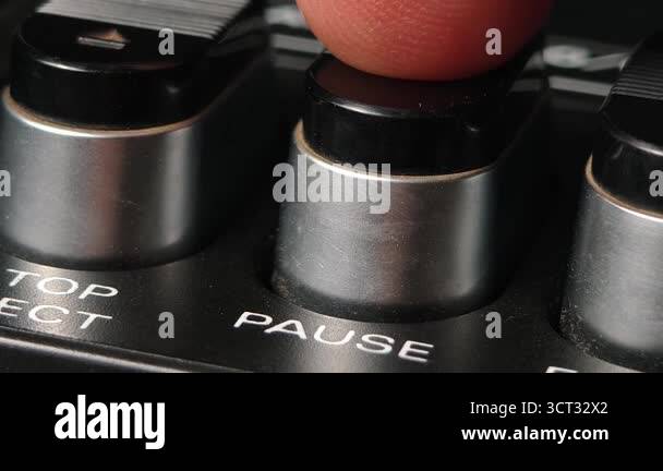 Extreme close-up of finger pressing pause button on vintage tape player ...