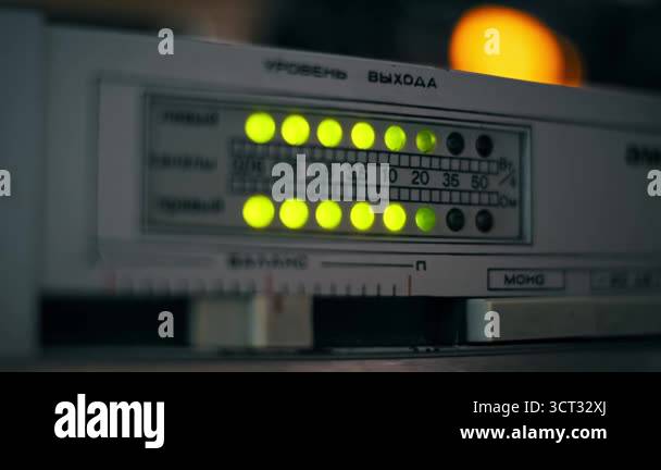 Low-light close-up of a retro audio amplifiers blinking LED level meter ...