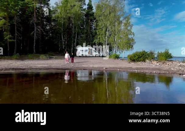 Visitors enjoy a relaxing stroll along the sandy shore of a tranquil ...