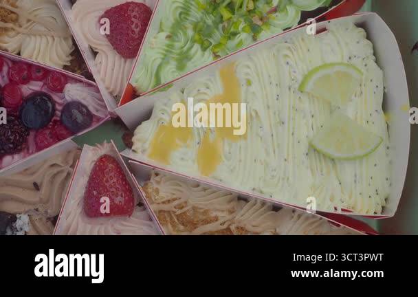 Colorful cake slices with various toppings are arranged for viewing ...