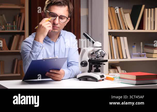 Close-up portrait scientist writing notes on clipboard while working ...