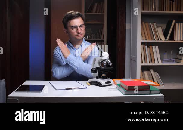 Young male scientist is making stop gesture with crossed arms while ...