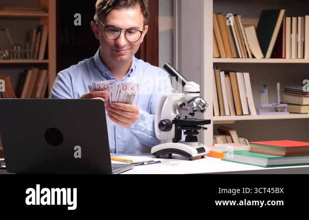 Close-up portrait young smiling scientist counting american banknotes ...