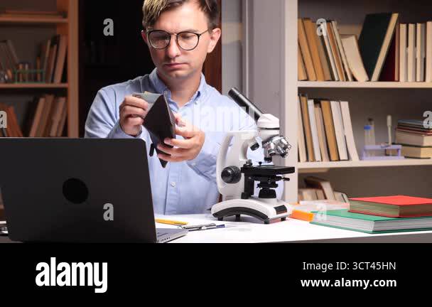Close-up portrait scientist taking money from wallet at his workplace ...