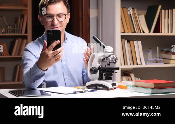Close-up portrait young scientist having video call on smartphone ...