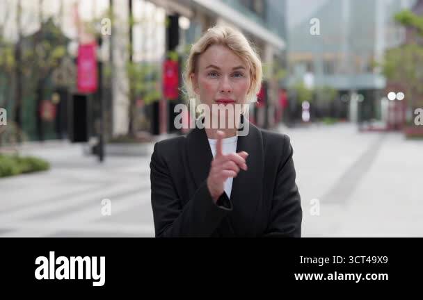 Portrait of serious businesswoman shakes finger saying No in downtown ...