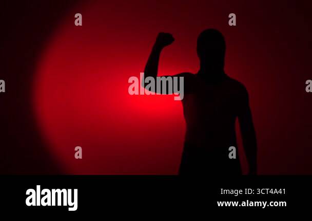 Man fighter silhouette flexing his bicep on a vibrant red background ...