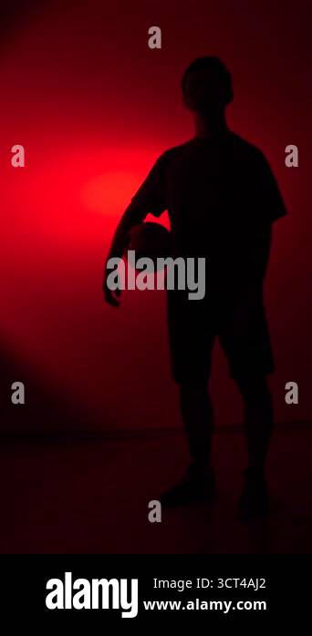 vertical video Male football player stands confidently with a soccer ...