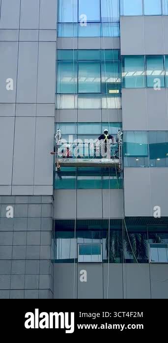 Professional high rise window cleaning service workers in gondola. Two ...