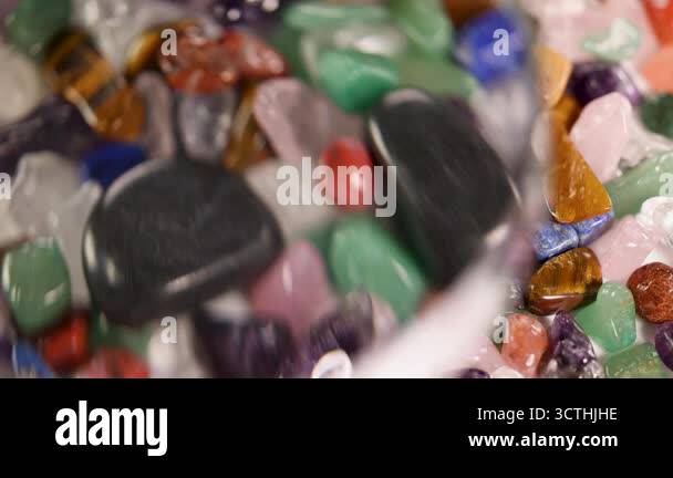 A magnifying glass reveals vibrant chakra stones, enhancing their ...