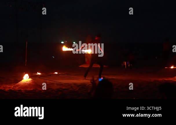 A captivating fire twirling act on a Phuket beach at night, showcasing ...