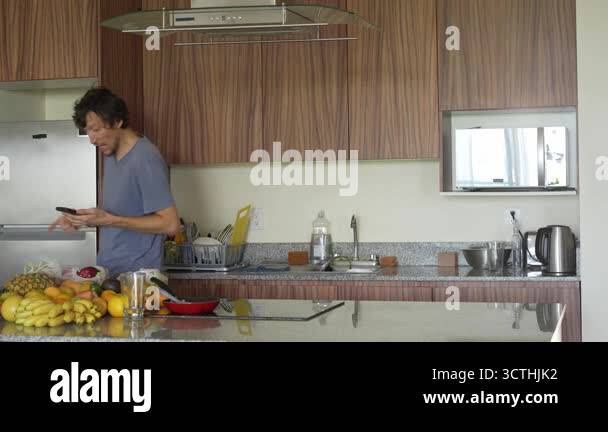 An angry man paces back and forth in the kitchen while talking to ...