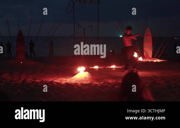 A captivating fire twirling act on a Phuket beach at night, with ...