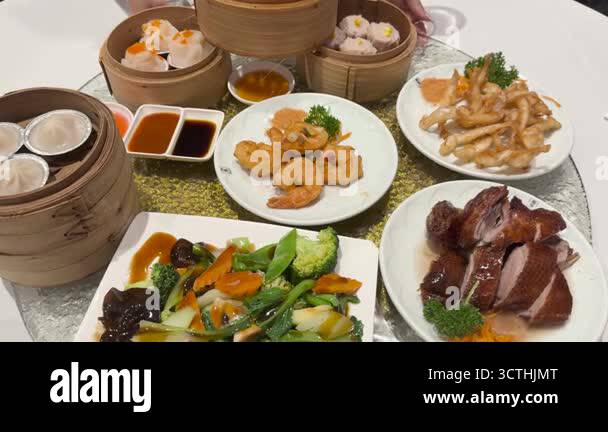 A vibrant display of dim sum dishes including shrimp, vegetables, and ...