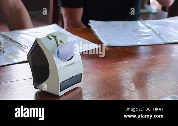 A person pulls tissue from a dispenser on a wooden table in a Phuket ...