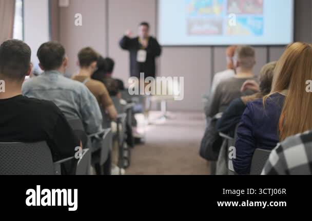 Audience seated and paying attention to a presenter speaking in a ...