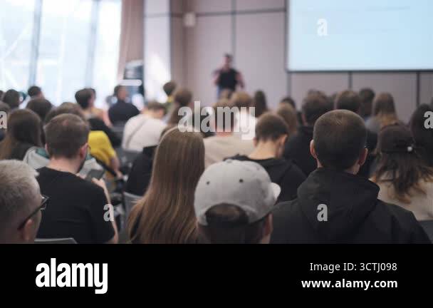 Small to mid-sized audience engaged in an indoor conference setting ...