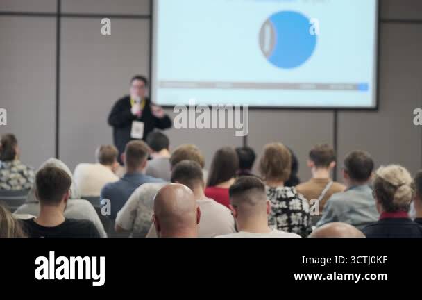 Audience attentively listening to a business presentation by a speaker ...