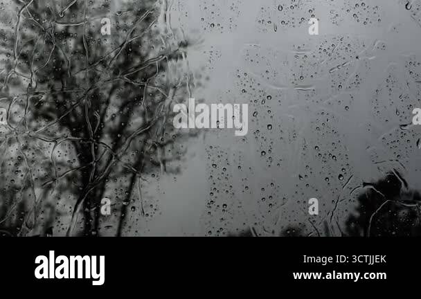 Rain falling outdoors with wet surface reflections. Moody weather ...