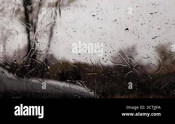 Rain falling outdoors with wet surface reflections. Moody weather ...