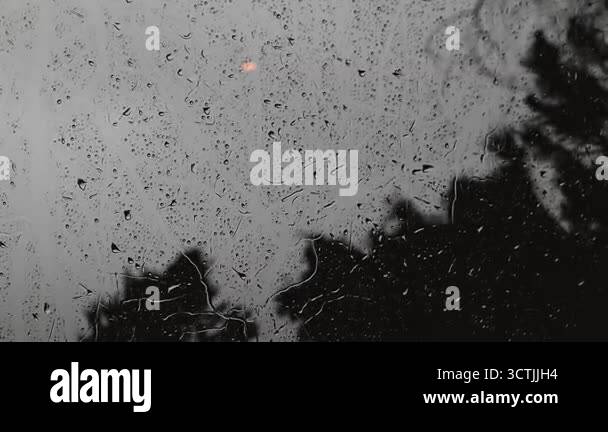 Rain falling outdoors with wet surface reflections. Moody weather ...