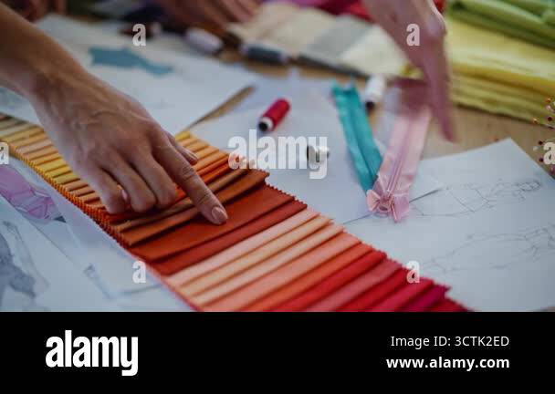 Fashion designer hands arranging color fabric swatches in creative ...