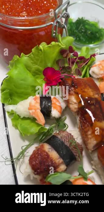 A close-up view of salmon roe being delicately spooned onto a sashimi ...