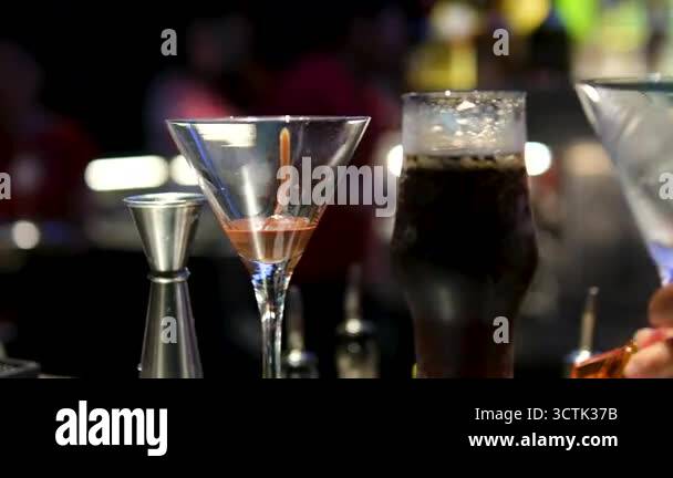 A professional bartender pours alcohol into a measuring cup The process ...