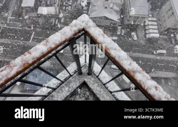 Heavy snow falls on rooftops and streets, creating a winter wonderland ...