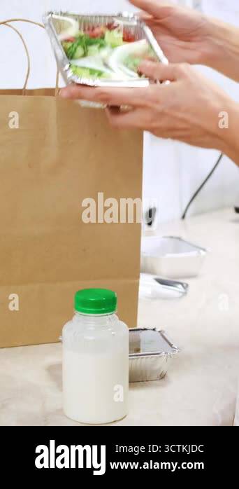 Cook pack delivery order in restaurant kitchen. Woman chef in white ...