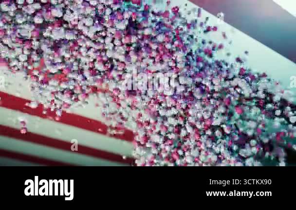 Colorful particles moving in a fluid, swirling motion against a red and ...