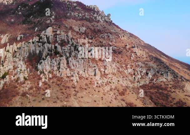 Drone view flying over a rocky mountain slope with unique rock ...