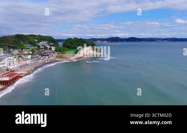 Aerial view of Kamakuro, Japan, showing a green cliffside, calm blue ...