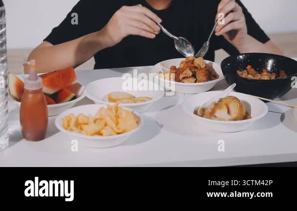 a person eats fried potato chips and a fork on the table. fast food ...