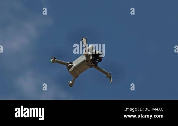 Modern DJI Mini 5 Pro drone hovering in clear blue sky, showcasing ...