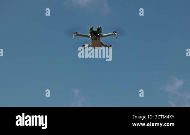 Modern DJI Mini 5 Pro drone hovering in clear blue sky, showcasing ...