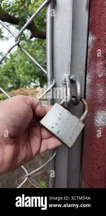 old padlock. mans hand open old metal padlock key. Wooden door in old ...