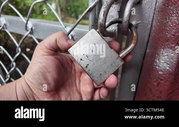 old padlock. mans hand open old metal padlock key. Wooden door in old ...