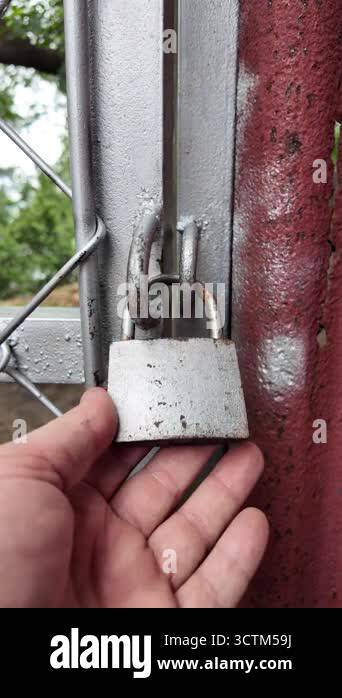 old padlock. mans hand open old metal padlock key. Wooden door in old ...
