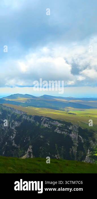 A rugged cliff covered with vegetation overlooks rolling plains and ...