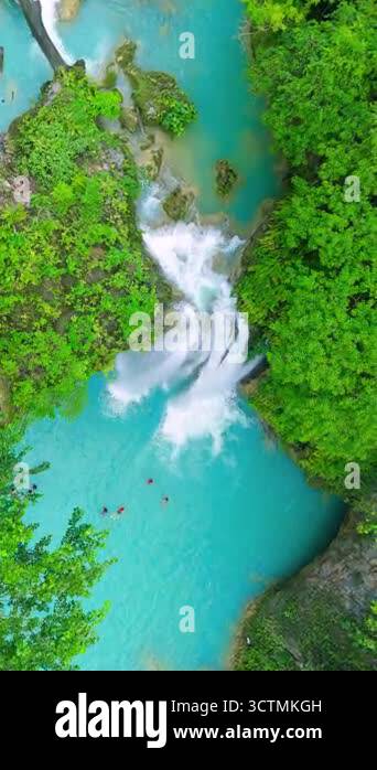 Aerial view of people swimming in the turquoise waters below a ...