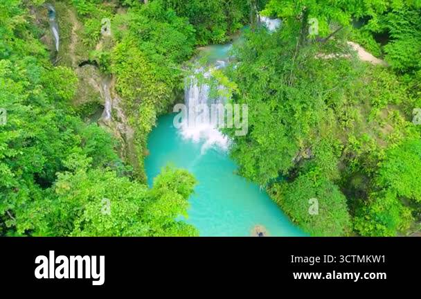 Aerial view of a multi-tiered waterfall cascading into vivid turquoise ...