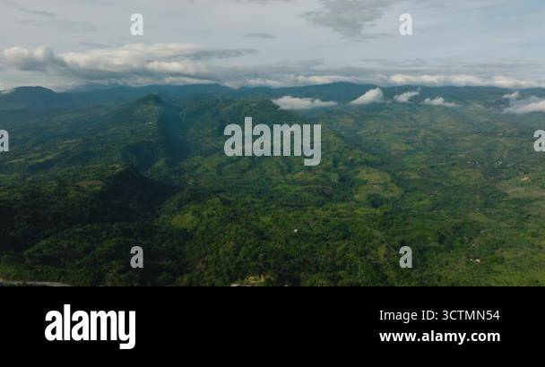 Tropical valley and mountain slopes with rainforest. Blue sky and ...