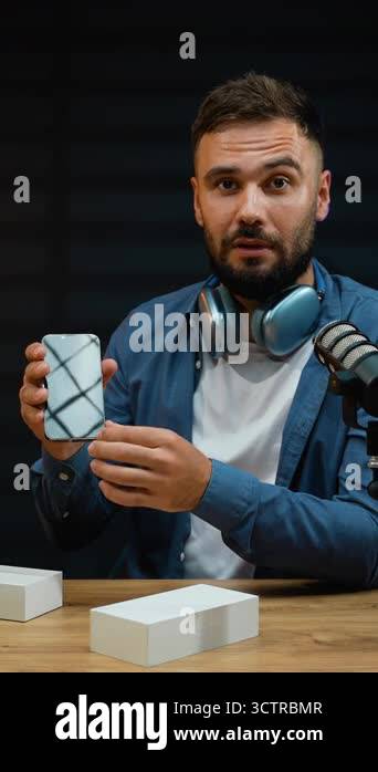 Male tech blogger recording an unboxing video of a new smartphone ...